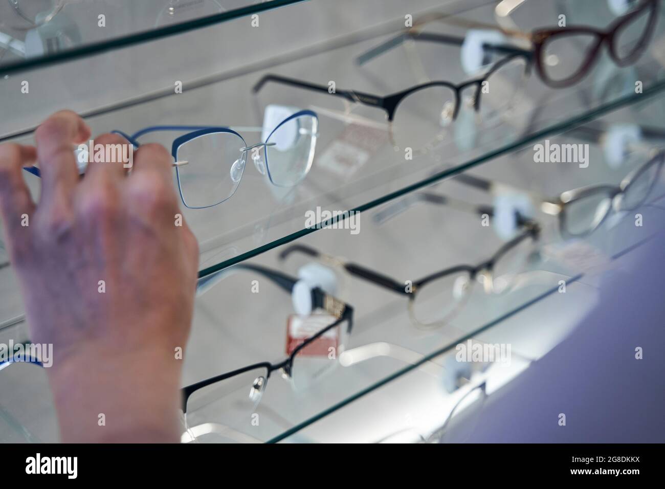 Young woman choosing eyeglasses in optical store Stock Photo - Alamy