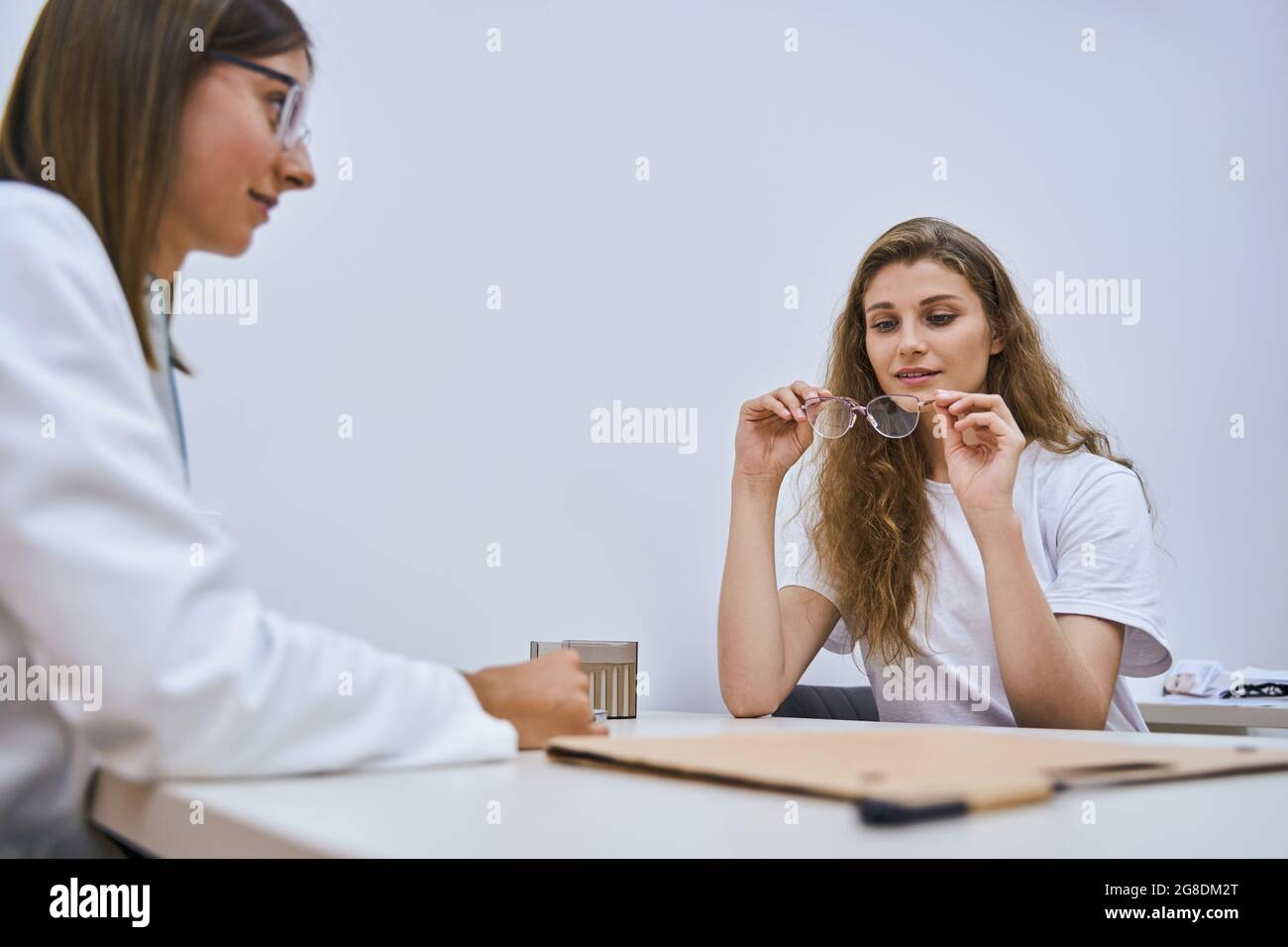 Charming young woman having appointment with optician in clinic Stock ...