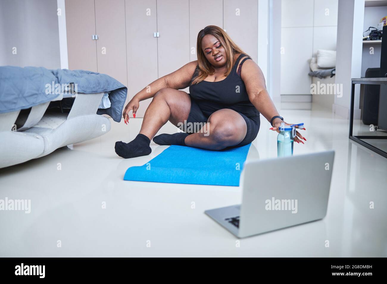 Beautiful plus-size lady using mat for daily exercising Stock Photo - Alamy