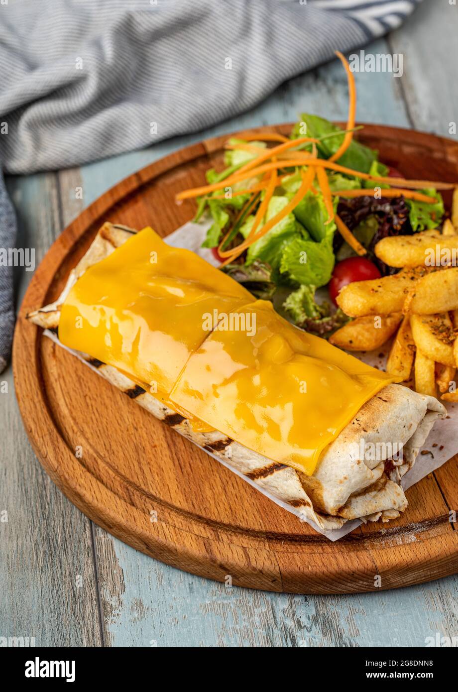cheddar cheese burrito with french fries and salad Stock Photo - Alamy