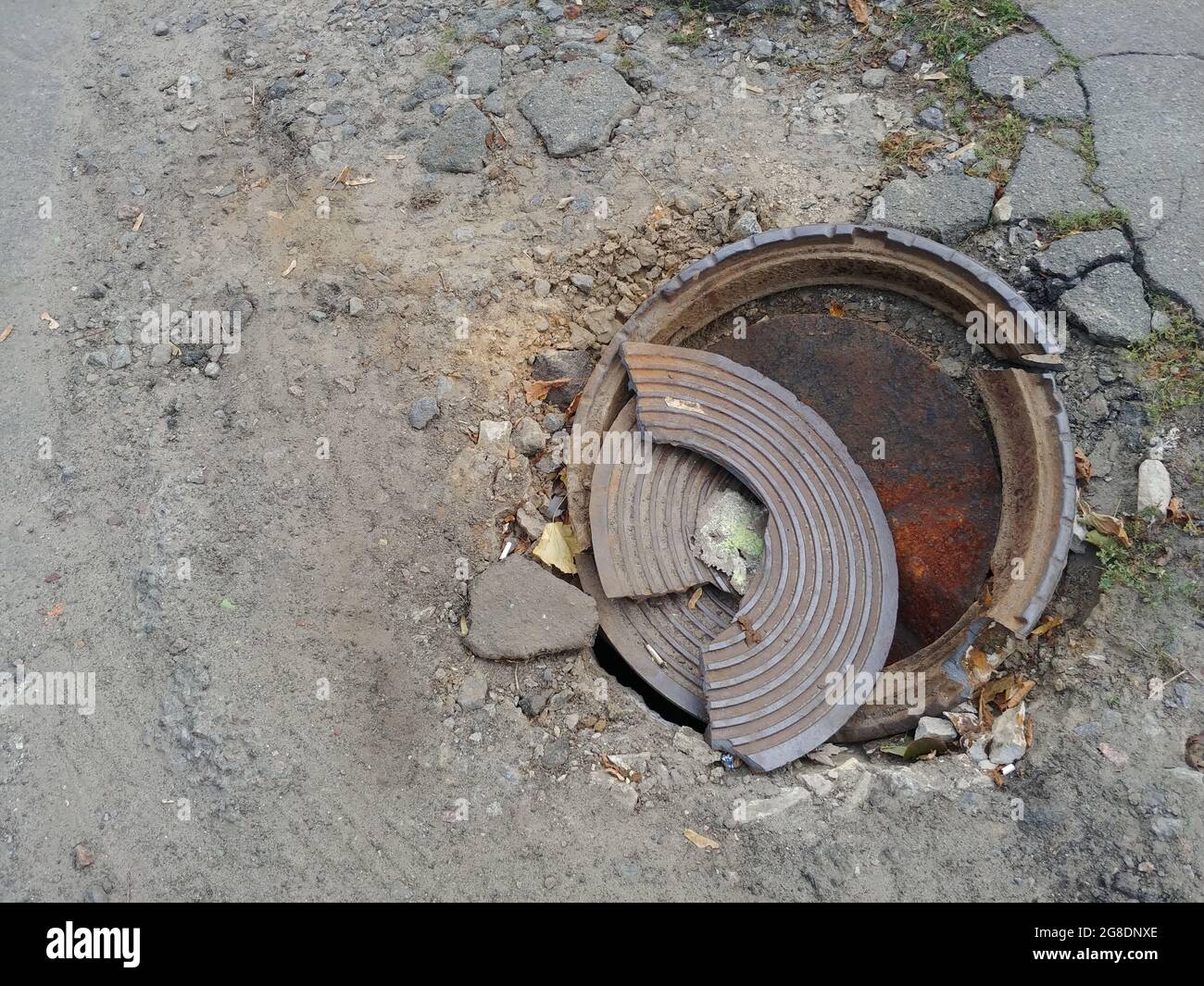 broken iron metallic manhole cover on empty hatch leads to city sewage ...