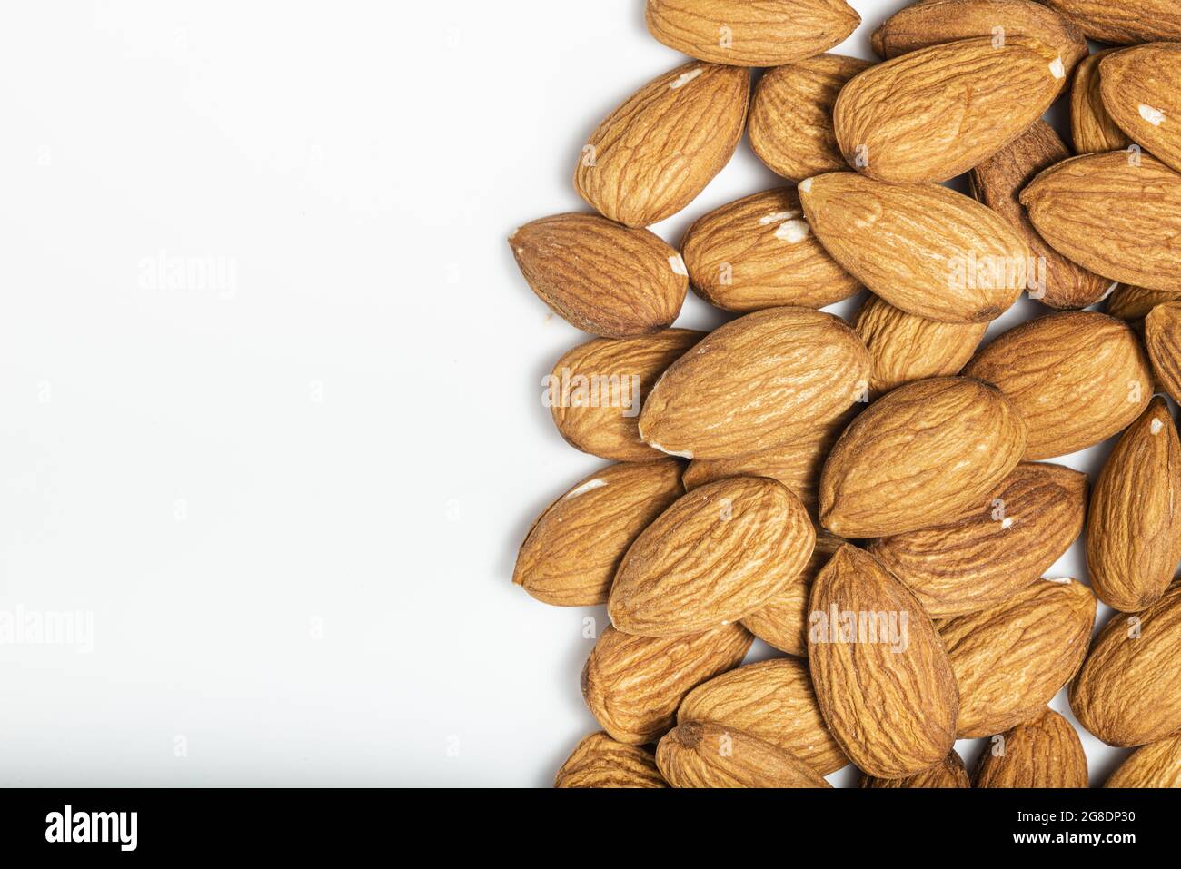 Closeup of beautiful almonds on an isolated white background with copy ...