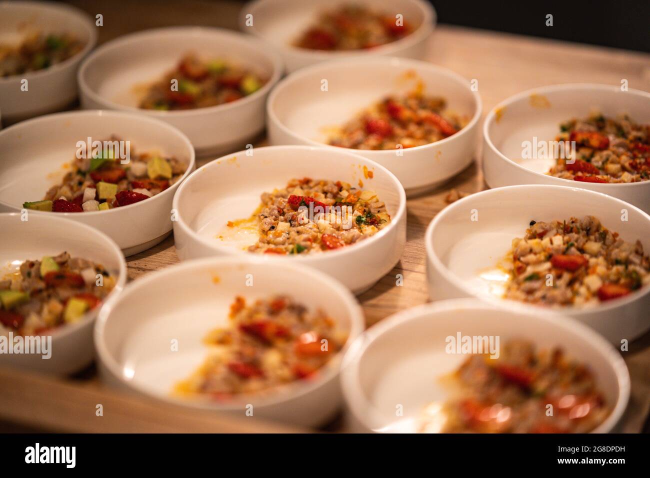 Restaurant table with rows of bowls with food Stock Photo - Alamy