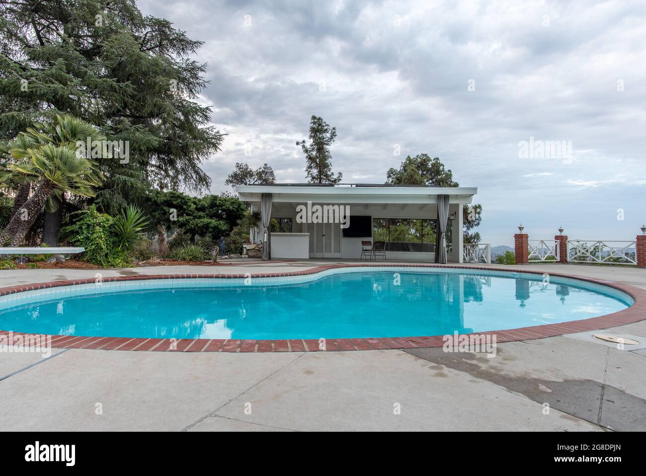 Tropical clouds reflected on the water surface of swimming pool on an ...