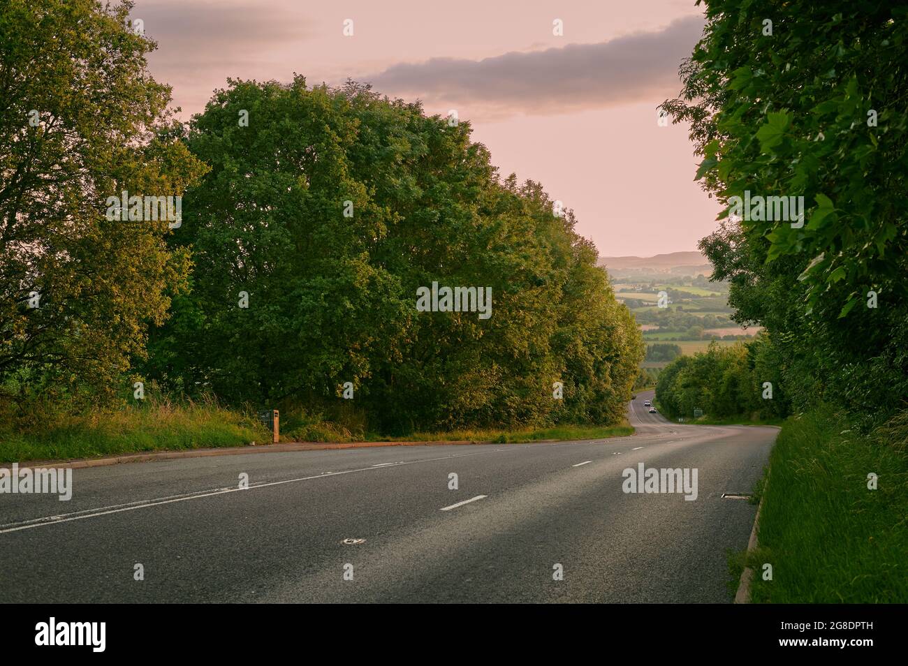 Country road in english countryside in summer with blue sky in the ...