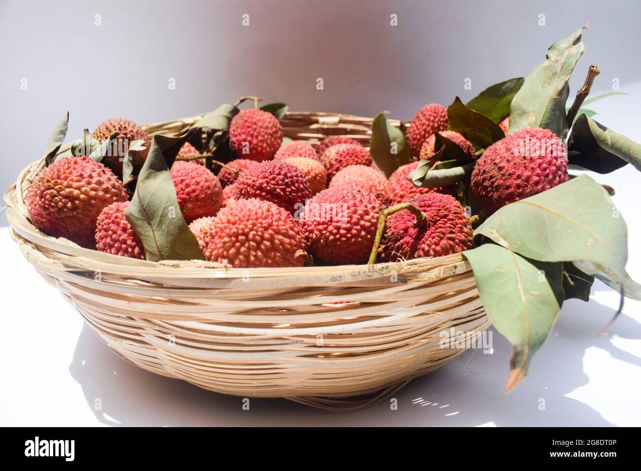 Side view of fresh plucked Lychees fruit in wicker bamboo basket ...