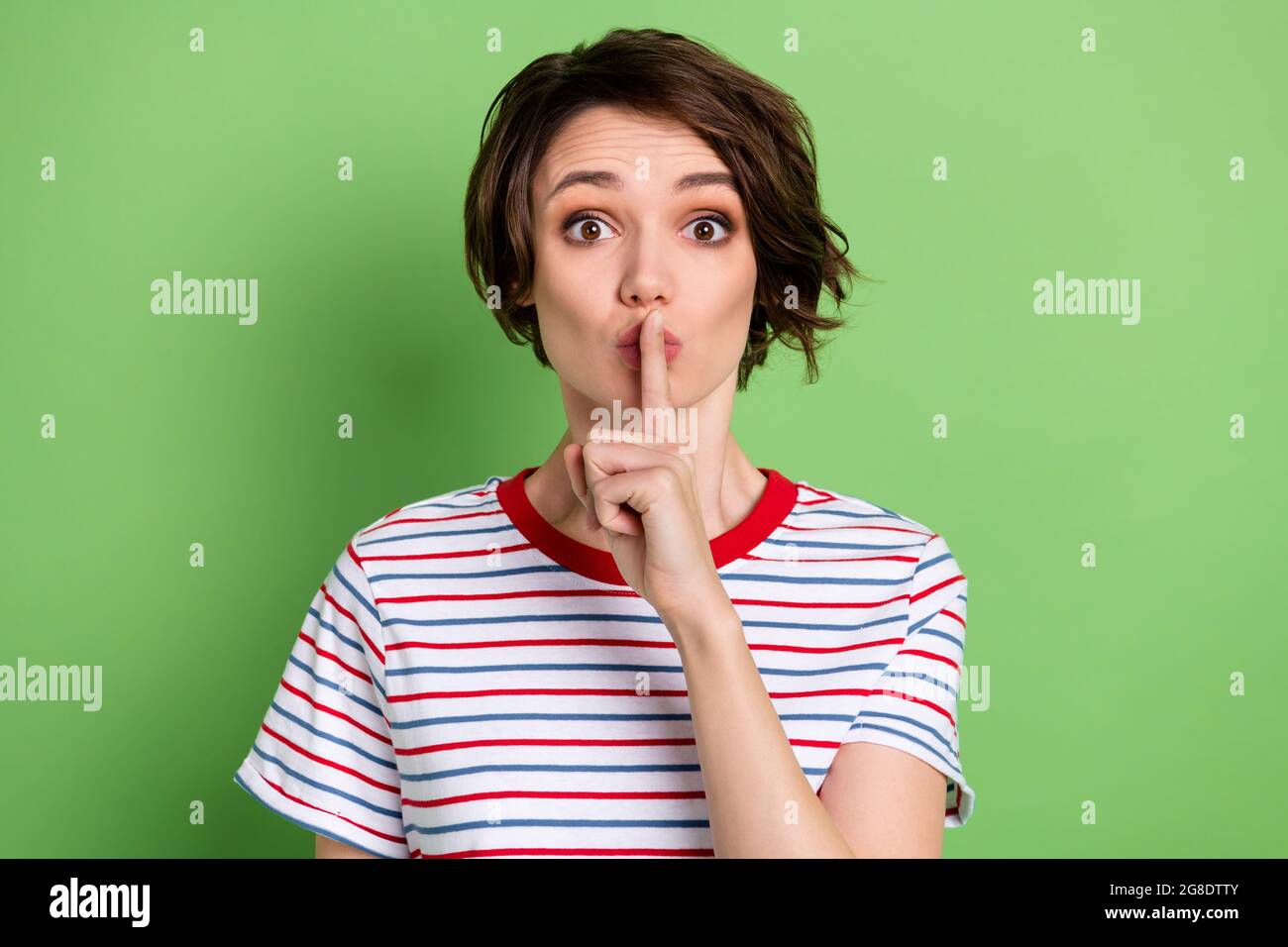 Portrait of puzzled young lady finger covering lips mouth look camera ...