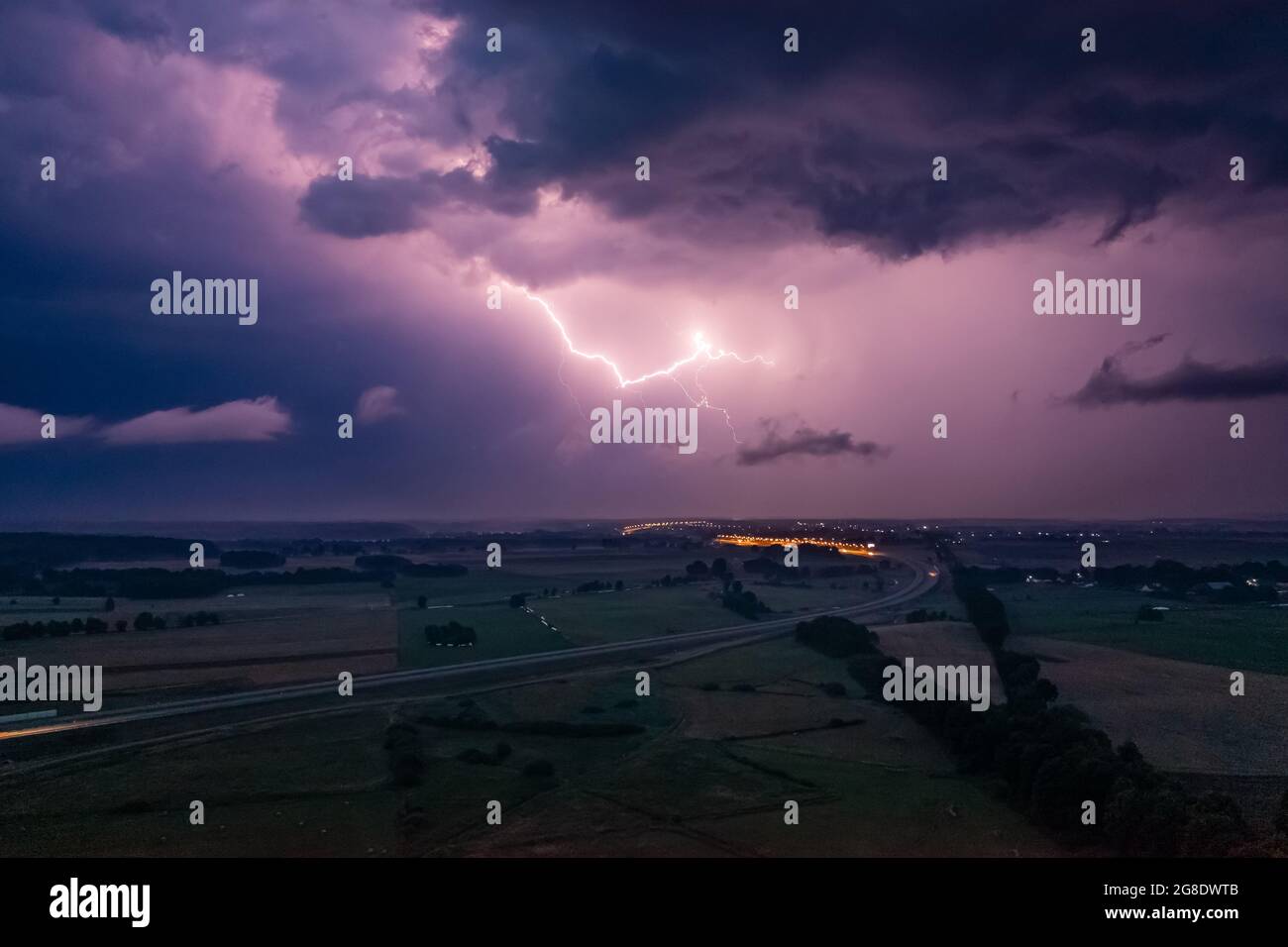 Heavy storm over express road and fields, dark clouds and lightning in ...