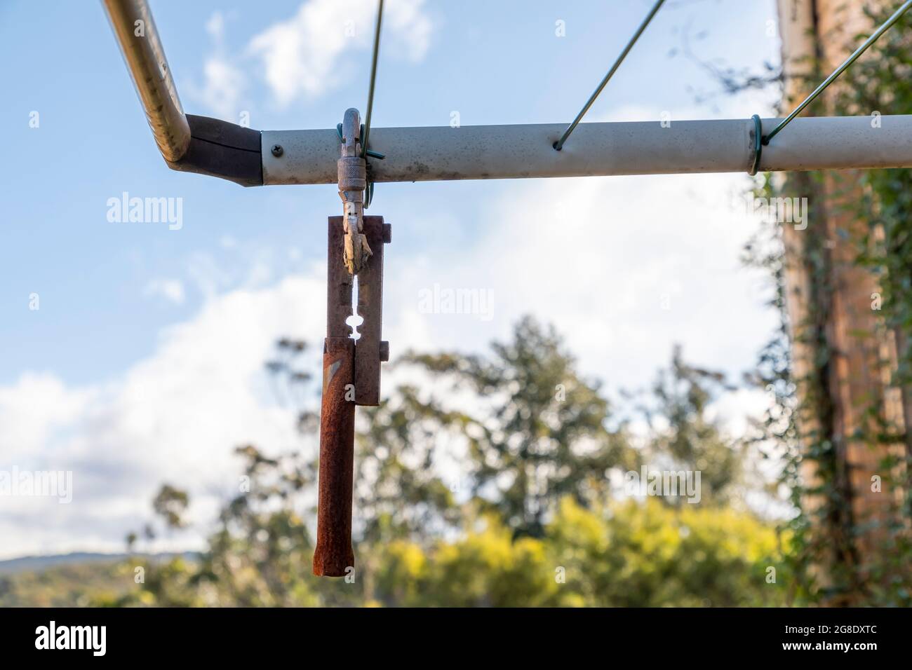 A metal counter weight hanging from a clothes line to stop it from ...