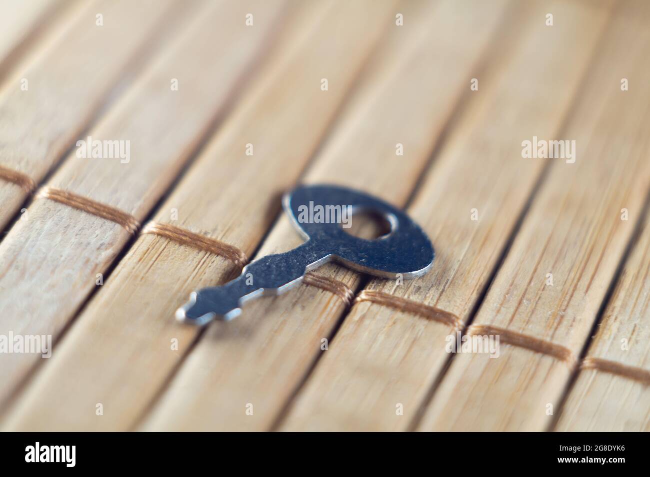 High angle shot of a silver key on a wooden surface Stock Photo - Alamy