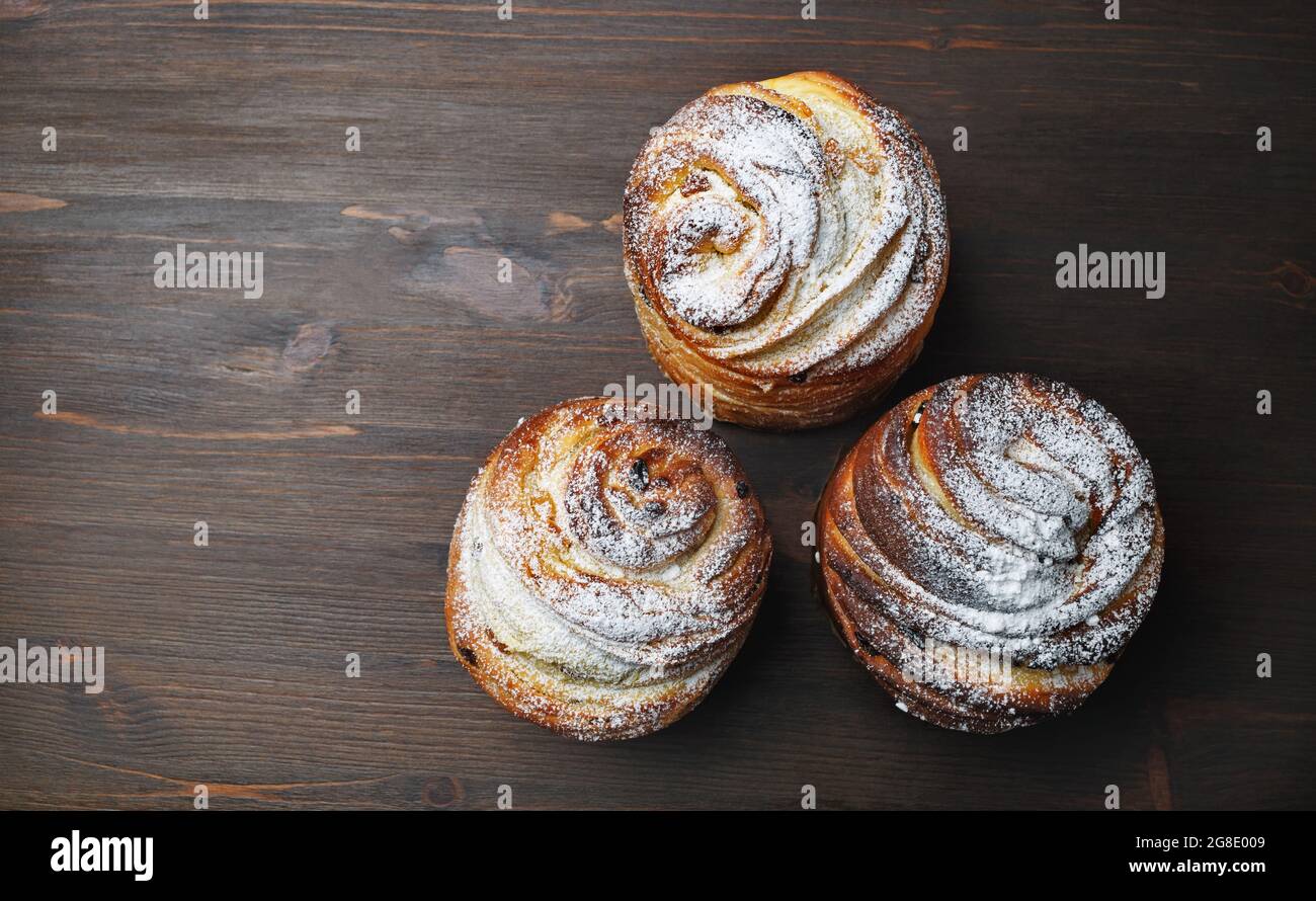 Three delicious sweet buns on wooden background. Flat lay Stock Photo ...