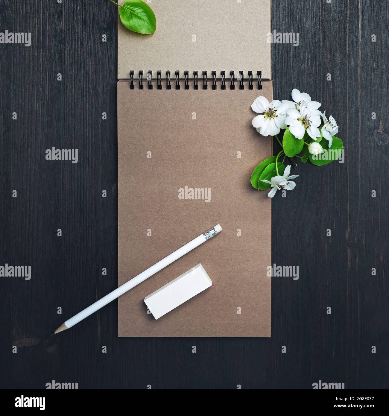 Blank kraft notepad, pencil, eraser and spring flowers on wood table ...