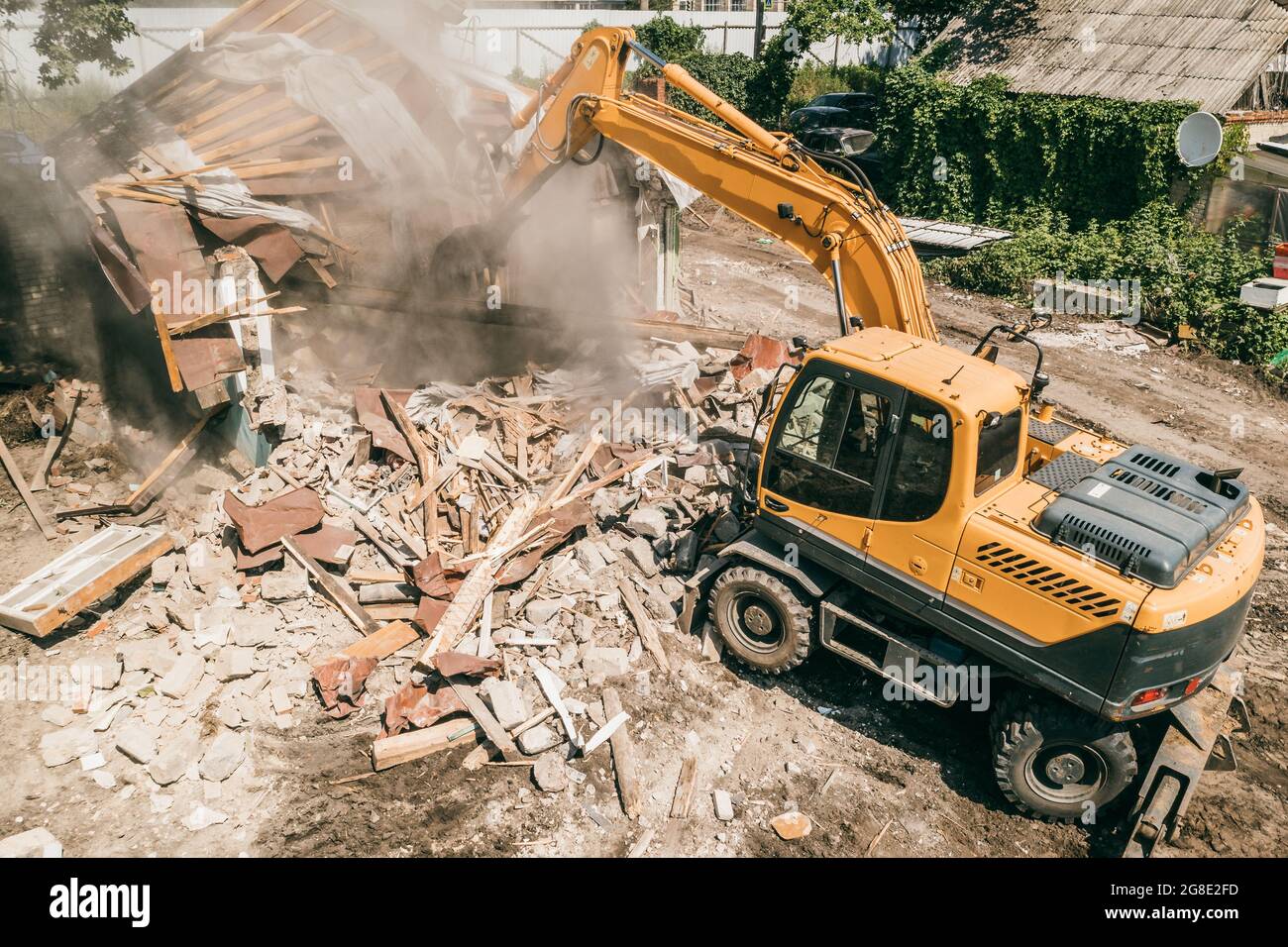 Demolition of building by industrial excavator. Bucket breaks walls and ...