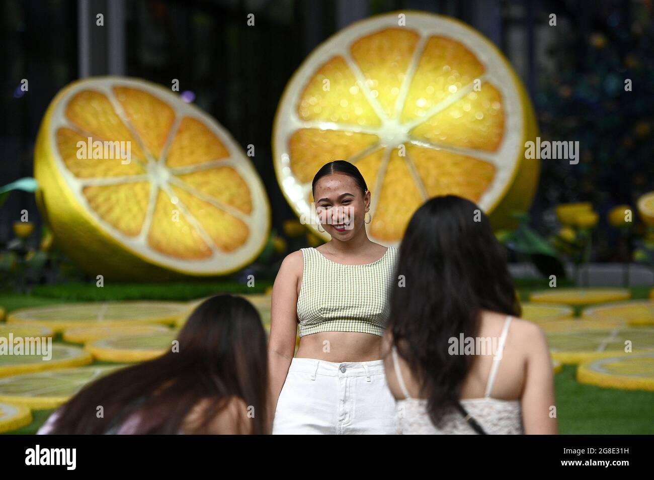 A woman poses in front of a large sliced lemon at “Citrovia”, part of a ...