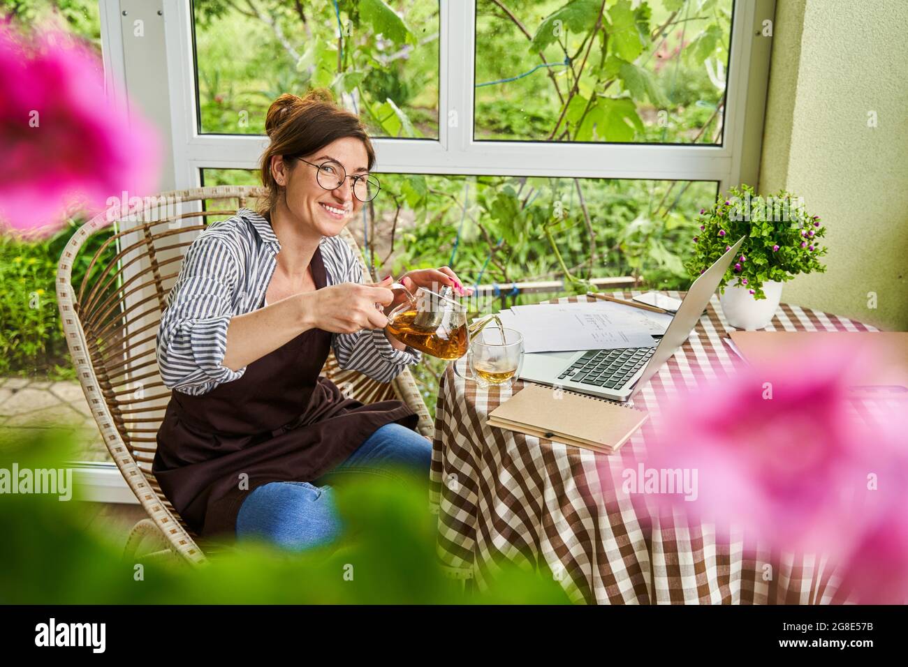 Smiling female person having break and drinking tea Stock Photo - Alamy