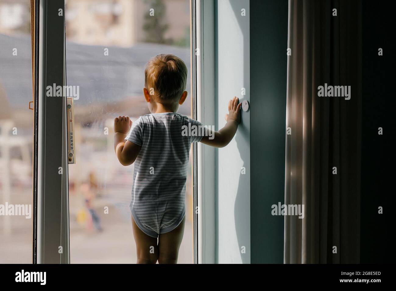 Baby boy on window sill Stock Photo - Alamy