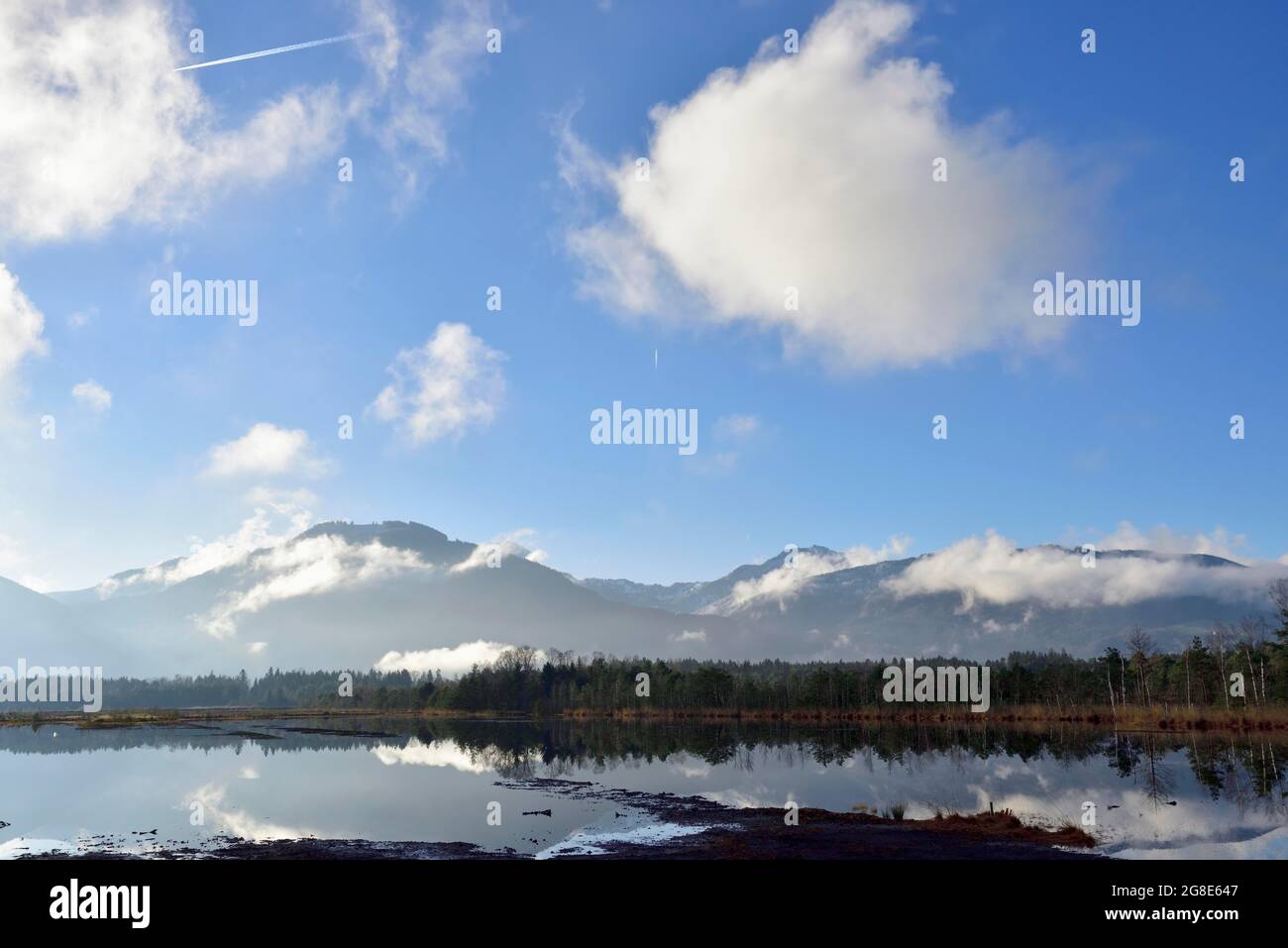Sky with clouds and condensation trails over moor landscape ...