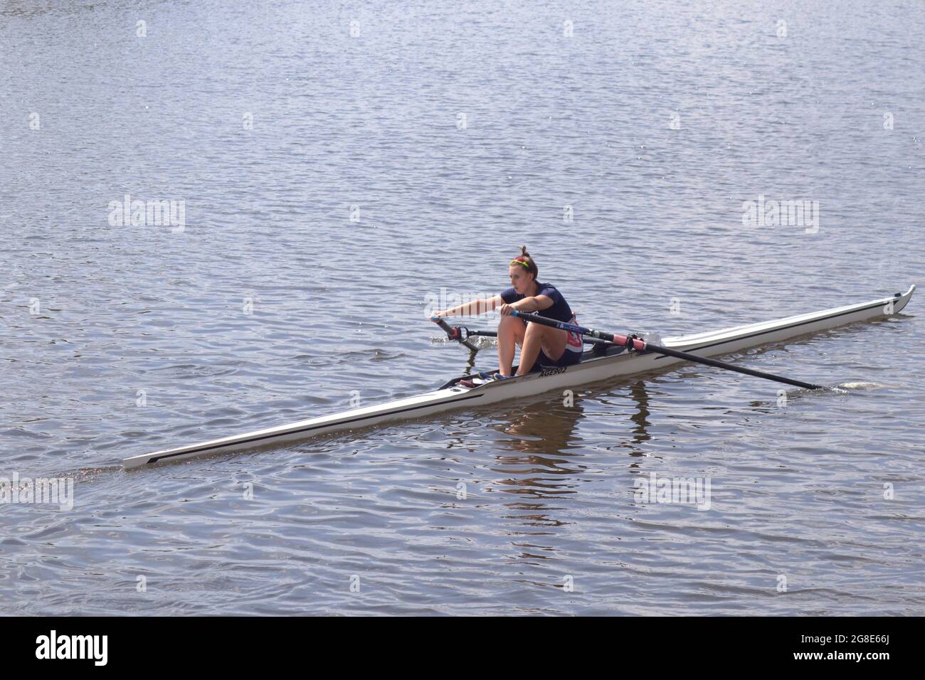 A young woman rows a skiff in the water at Salford Quays, Salford ...