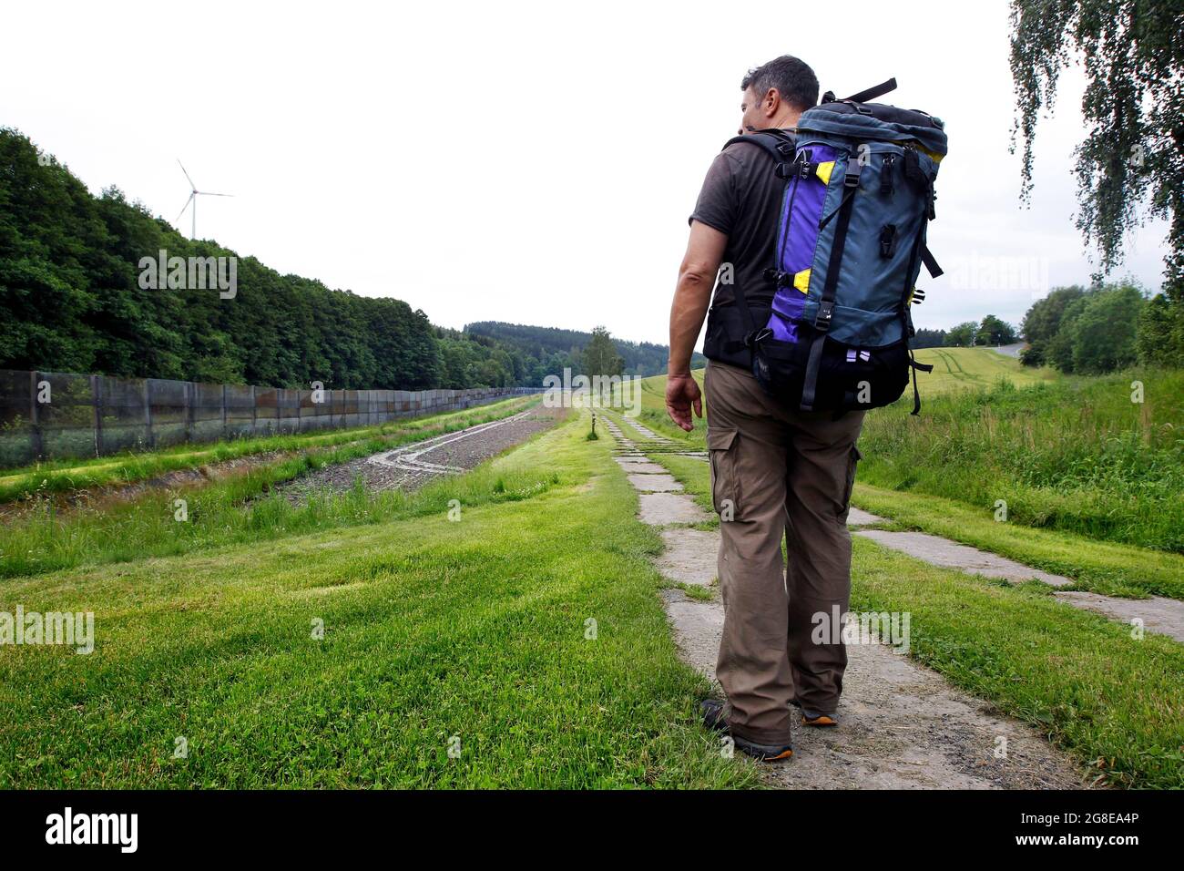 Man with backpack, hiker, border fortification with column path ...