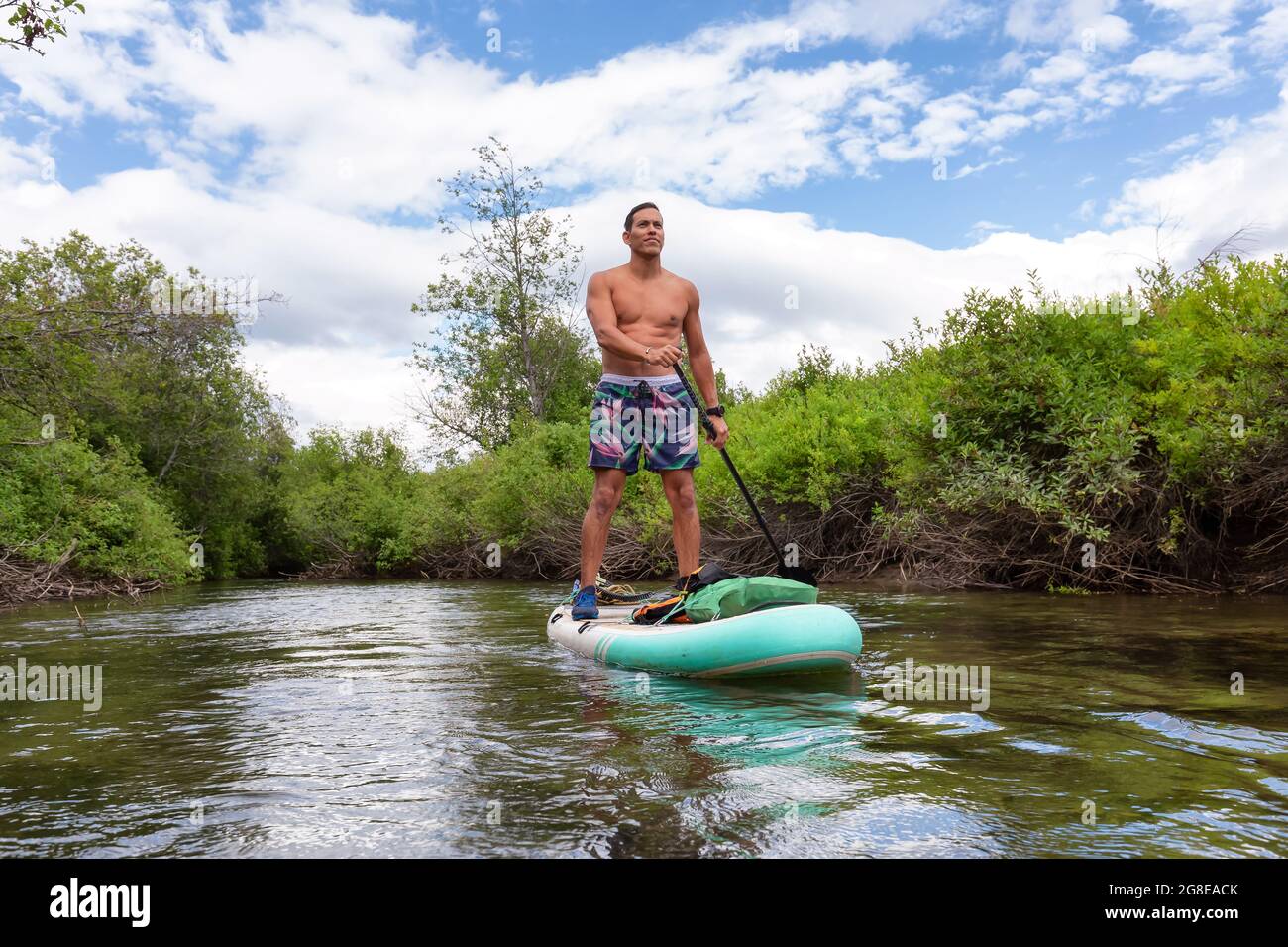 Adventurous Hispanic Adult Athletic Man paddle boarding Stock Photo - Alamy