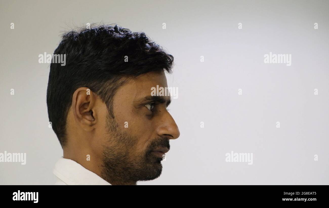 Side view of a South Asian male with a stubble looking directly ahead ...
