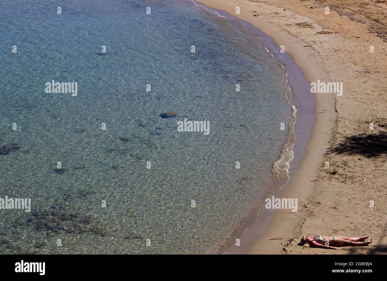 A tourist sunbathes on a beach on the island of Crete, Greece Stock ...
