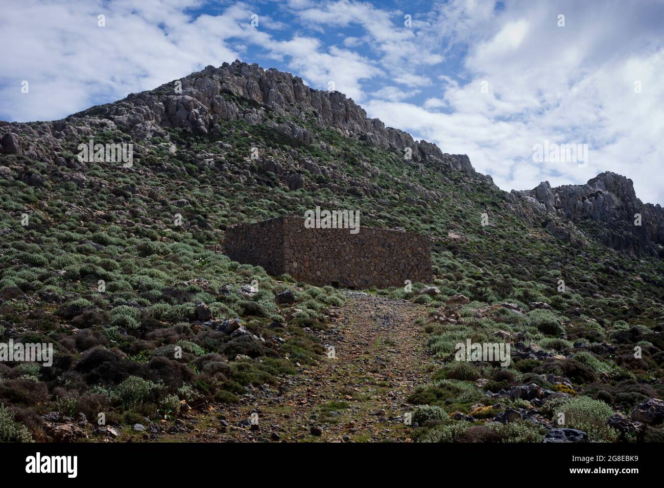 A stone structure at the base of a rocky outcrop on the island of Crete ...