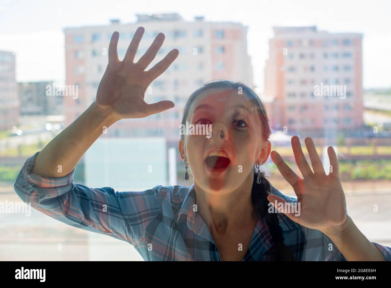 faces grimacing through the glass of the balcony Stock Photo - Alamy