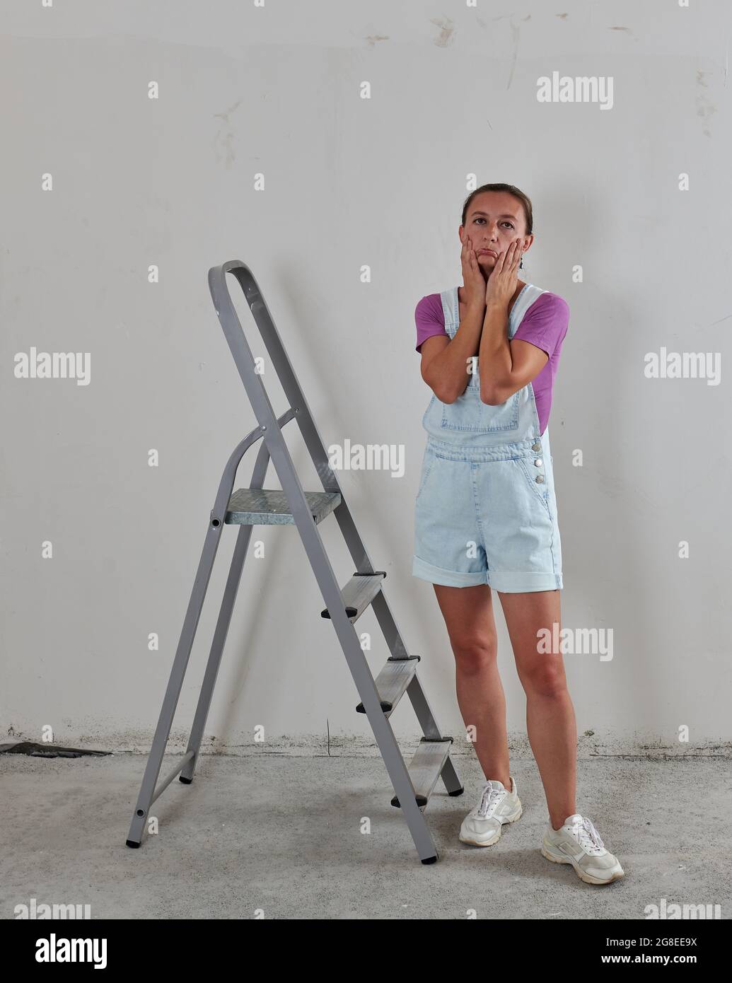 a sad repairman stands by the ladder Stock Photo - Alamy