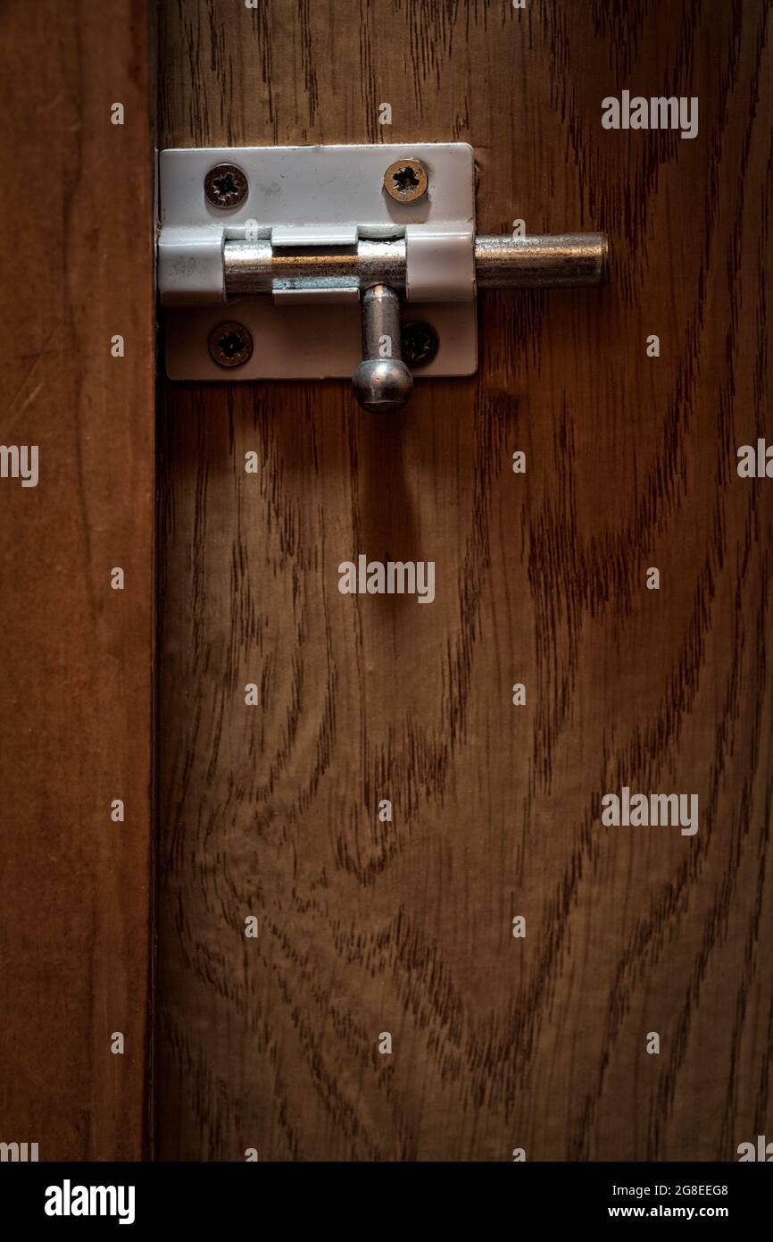 A small white metal latch on a wooden door Stock Photo - Alamy
