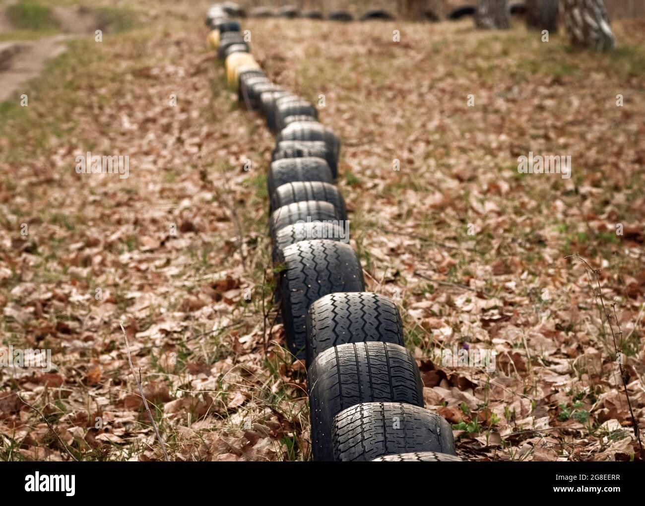 A small fence made of old tires dug into the ground Stock Photo - Alamy