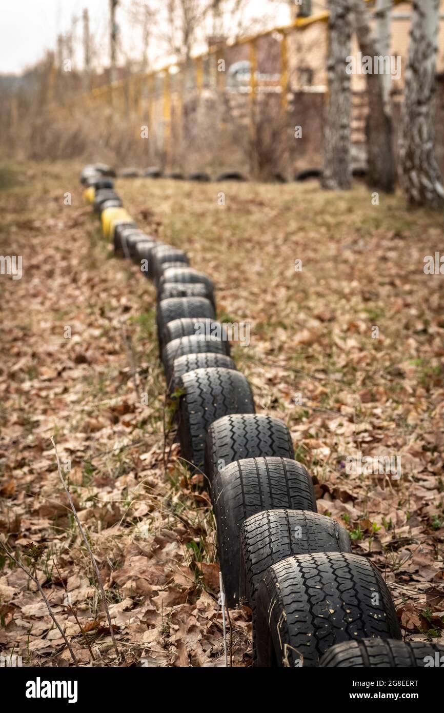 A small fence made of old tires dug into the ground Stock Photo - Alamy