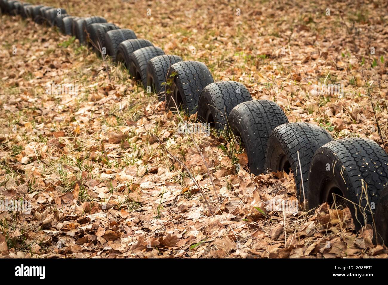 A small fence made of old tires dug into the ground Stock Photo - Alamy