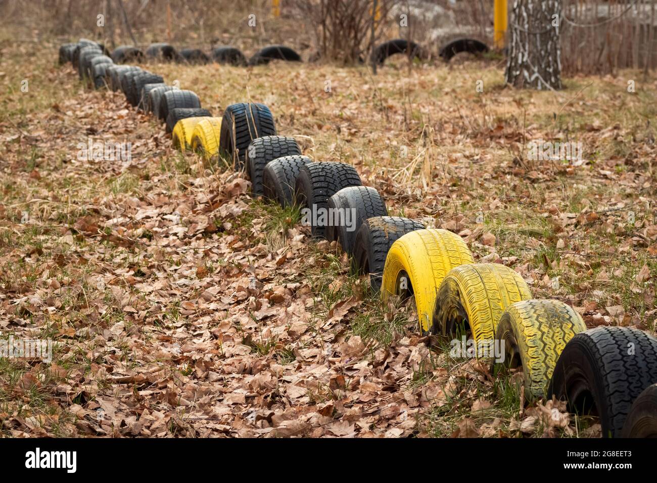 A small fence made of old tires dug into the ground Stock Photo - Alamy