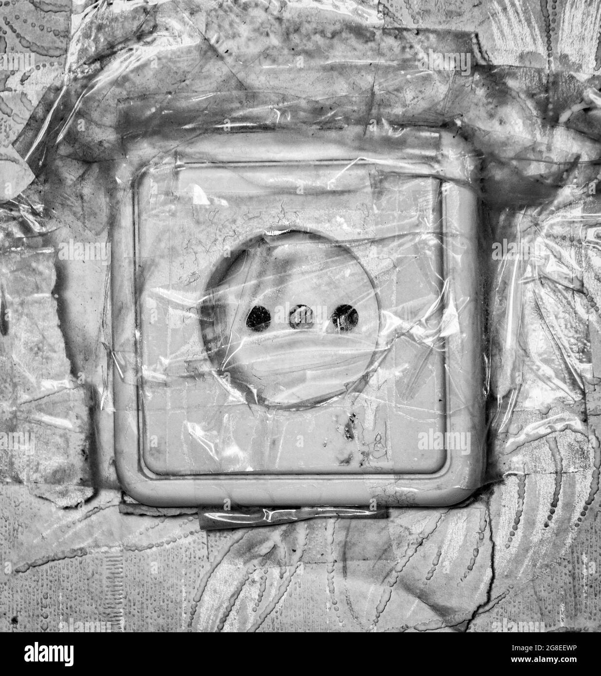 Close-up of an old broken electrical outlet sealed with transparent ...