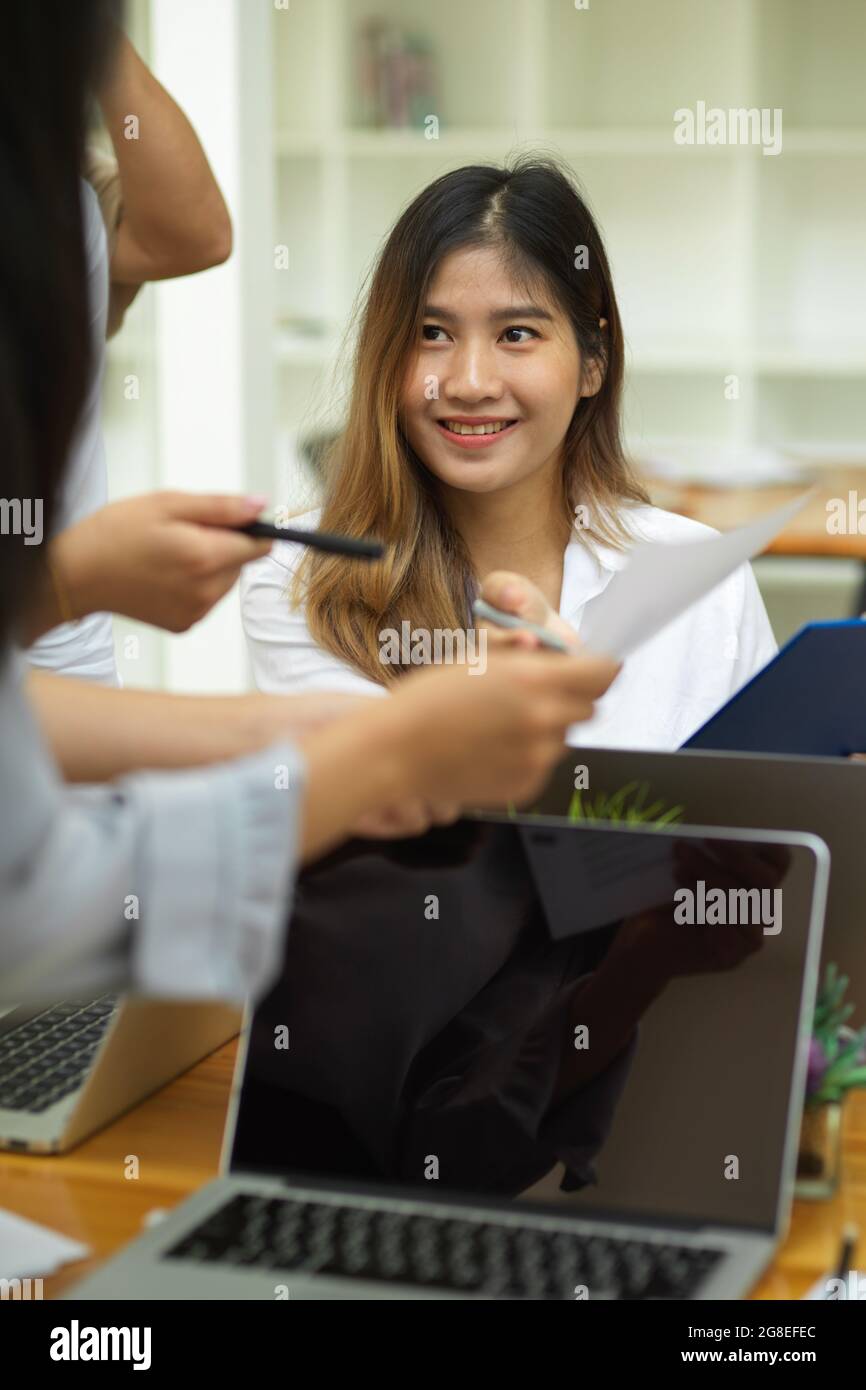 Portrait of attractive asian female trainee smiling while her manager ...