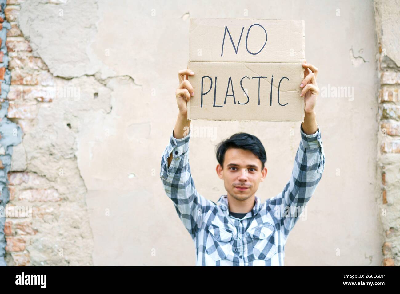 Young man with the inscription on the cardboard no plastic. Caucasian ...