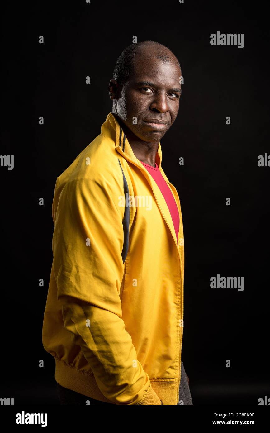 Side view of an African American man standing looking at camera black ...