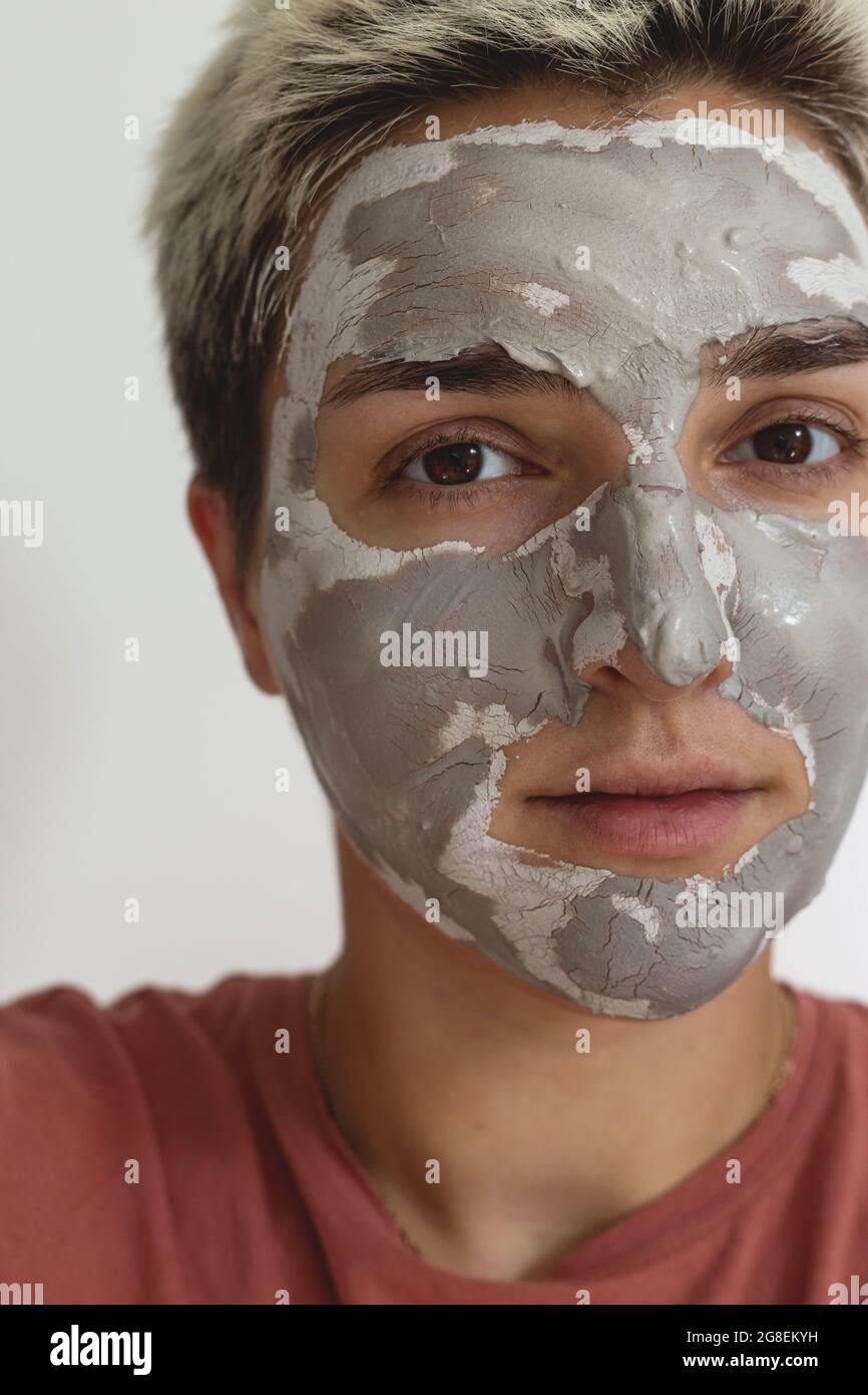 Cropped shot of woman apply grey green skincare clay mask on face ...