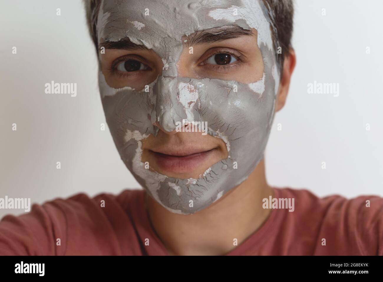 Cropped shot of woman apply grey green skincare clay mask on face ...
