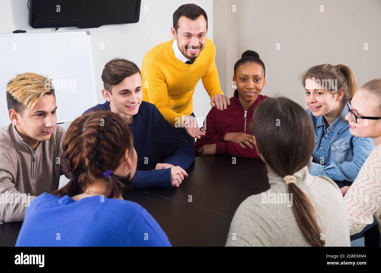 cheerful classmates having difficult project to complete during class ...