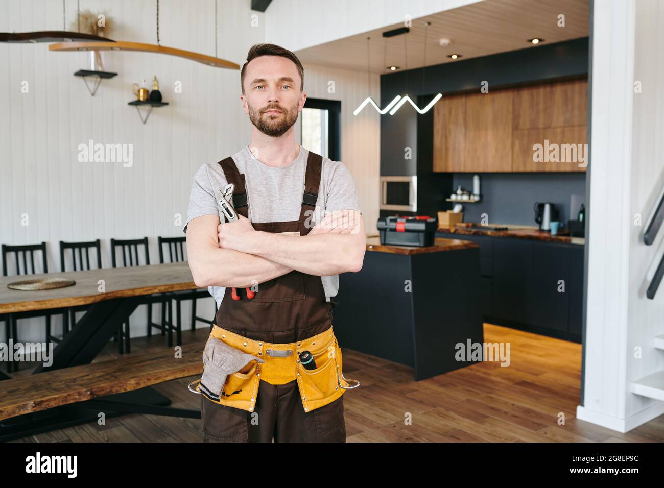 Young serious plumber with wrench crossing arms by chest Stock Photo ...