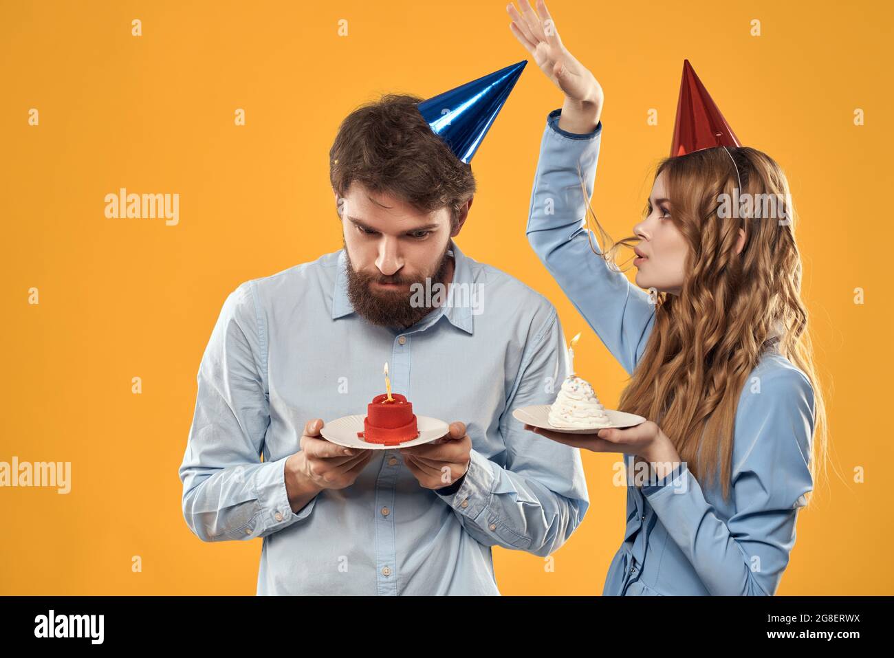 young couple birthday party fun caps on the head yellow background ...
