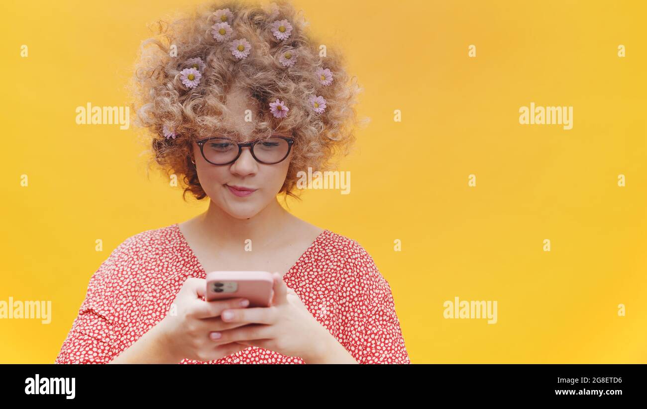 Attractive girl wearing nerdy spectacles holding a mobile phone in her ...