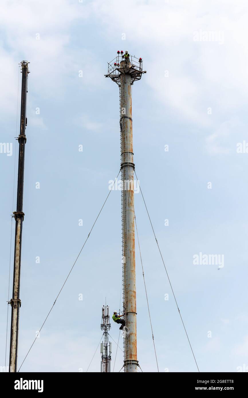Tall pipe and mobile crane against the sky. Preparatory work for ...