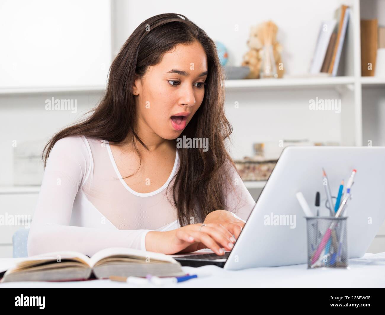 girl reading info in laptop and surprised Stock Photo - Alamy