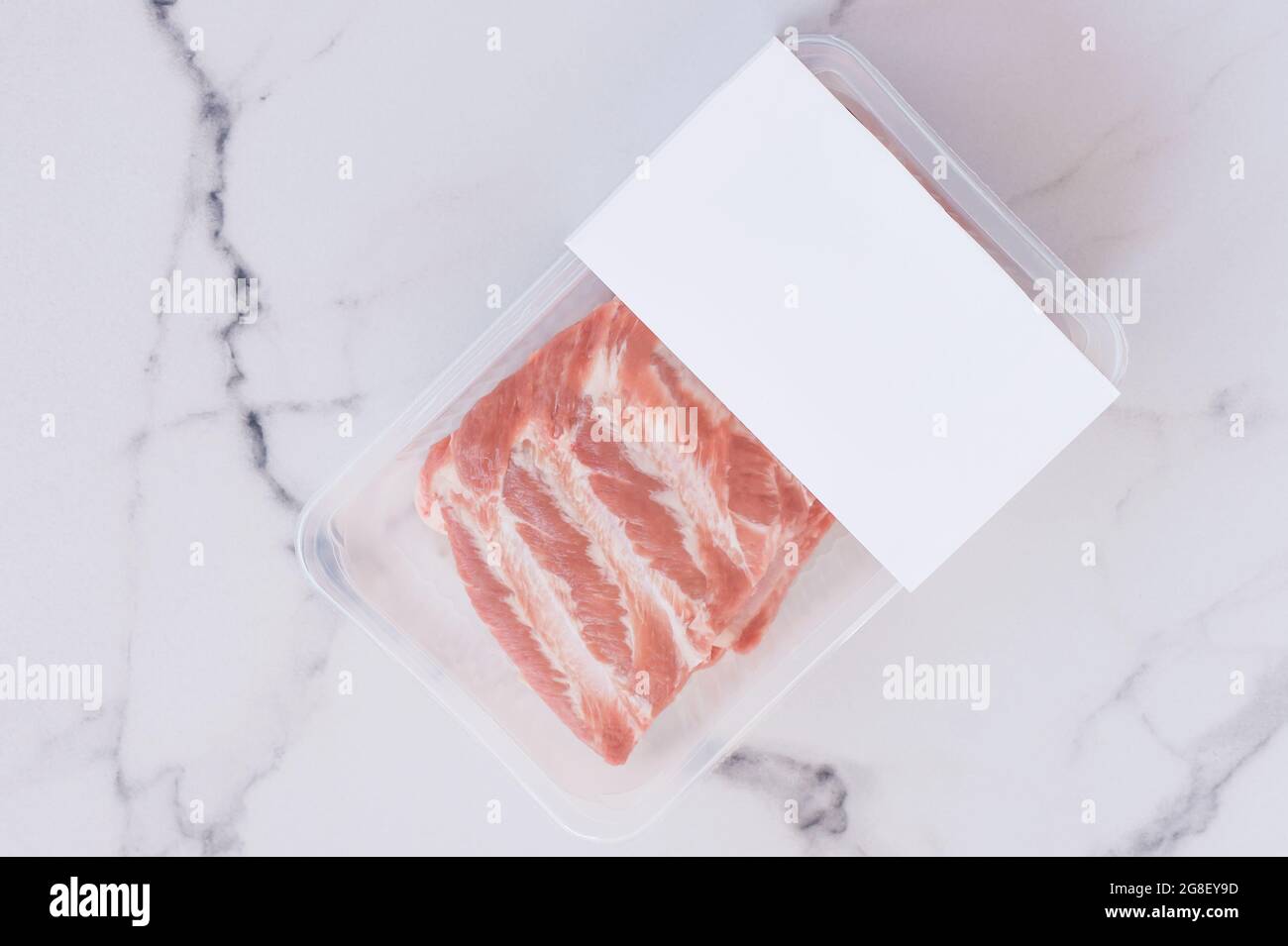 Raw pork ribs in vacuum packaging on marble background, logo mockup for ...