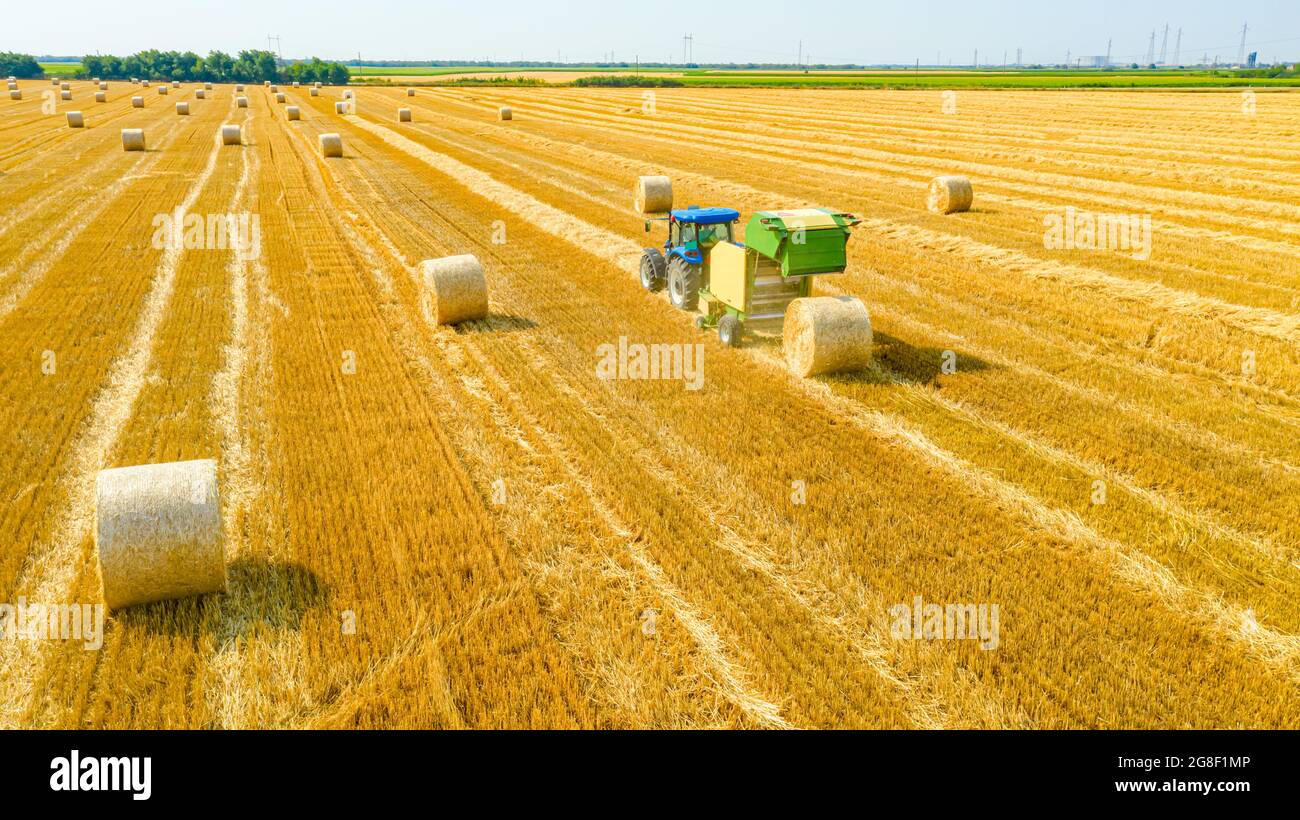 Above top view on tractor as pulling round baler, machine that rolls up ...