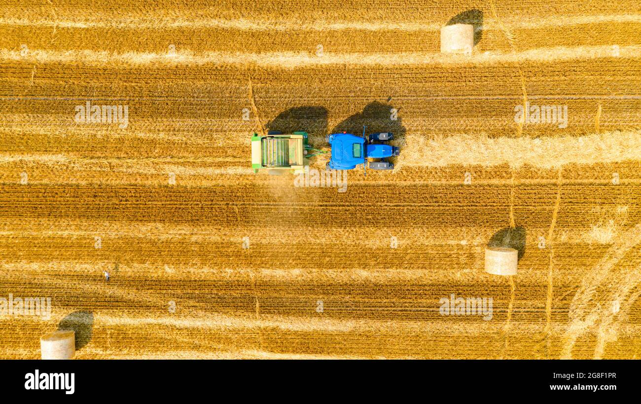 Above top view on tractor as pulling round baler, machine that rolls up ...