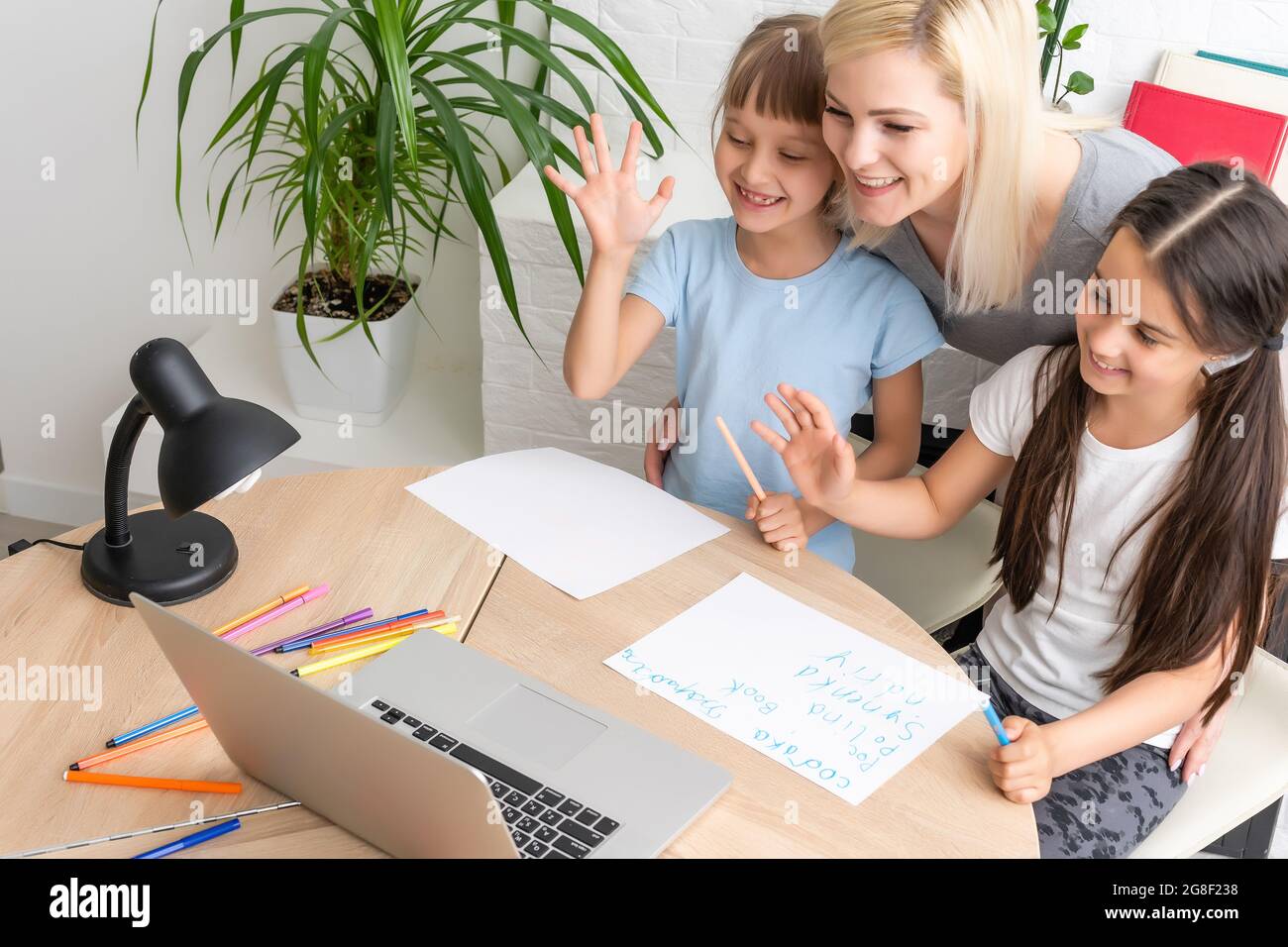 Woman tutor or foster parent mum helping cute caucasian school child ...